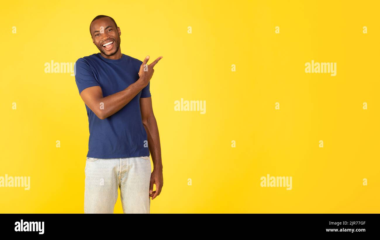 African Man Pointing Finger Aside At Empty Space, Yellow Background ...