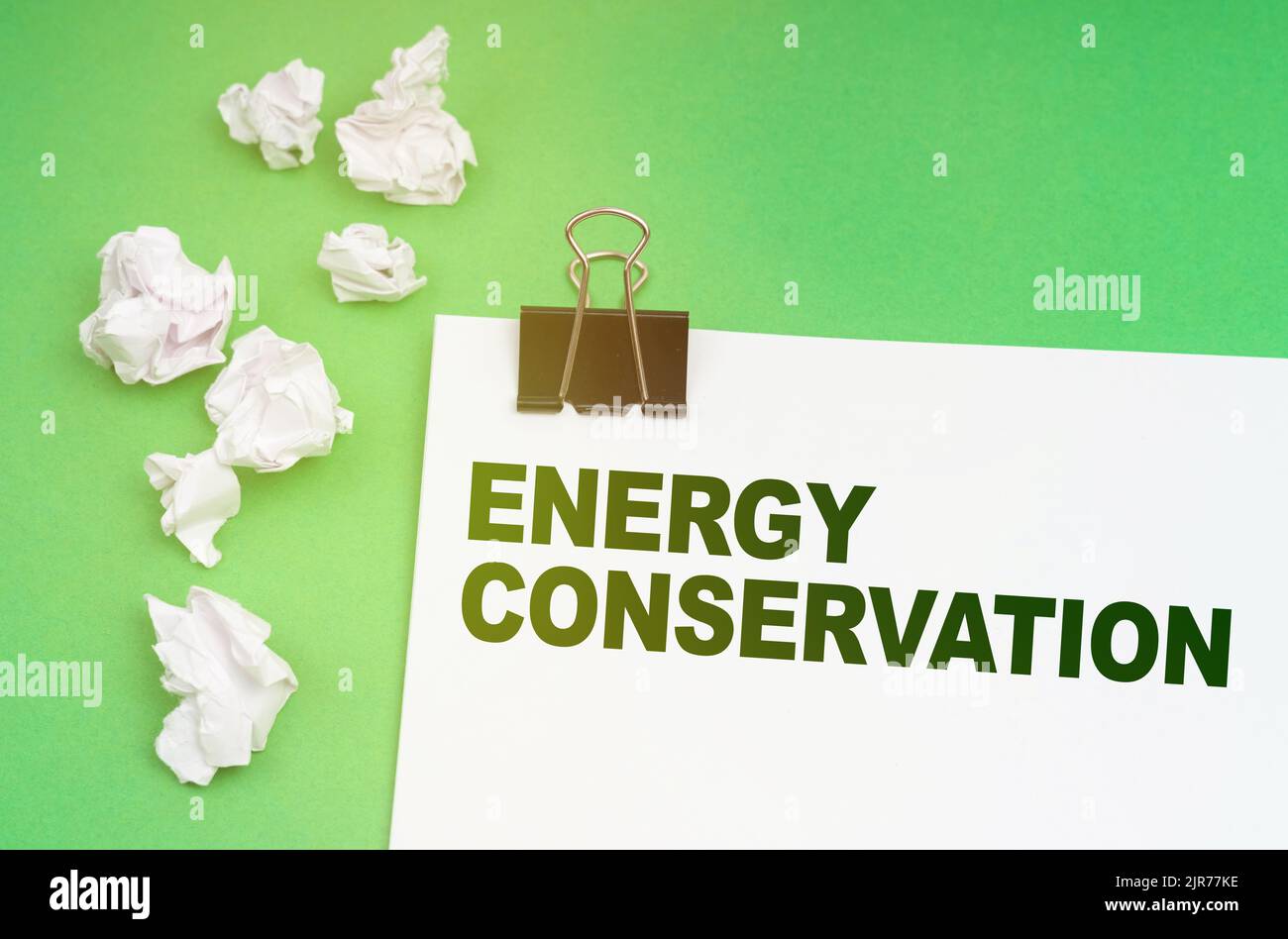 Ecology concept. On a green background, crumpled paper and a sheet with ...