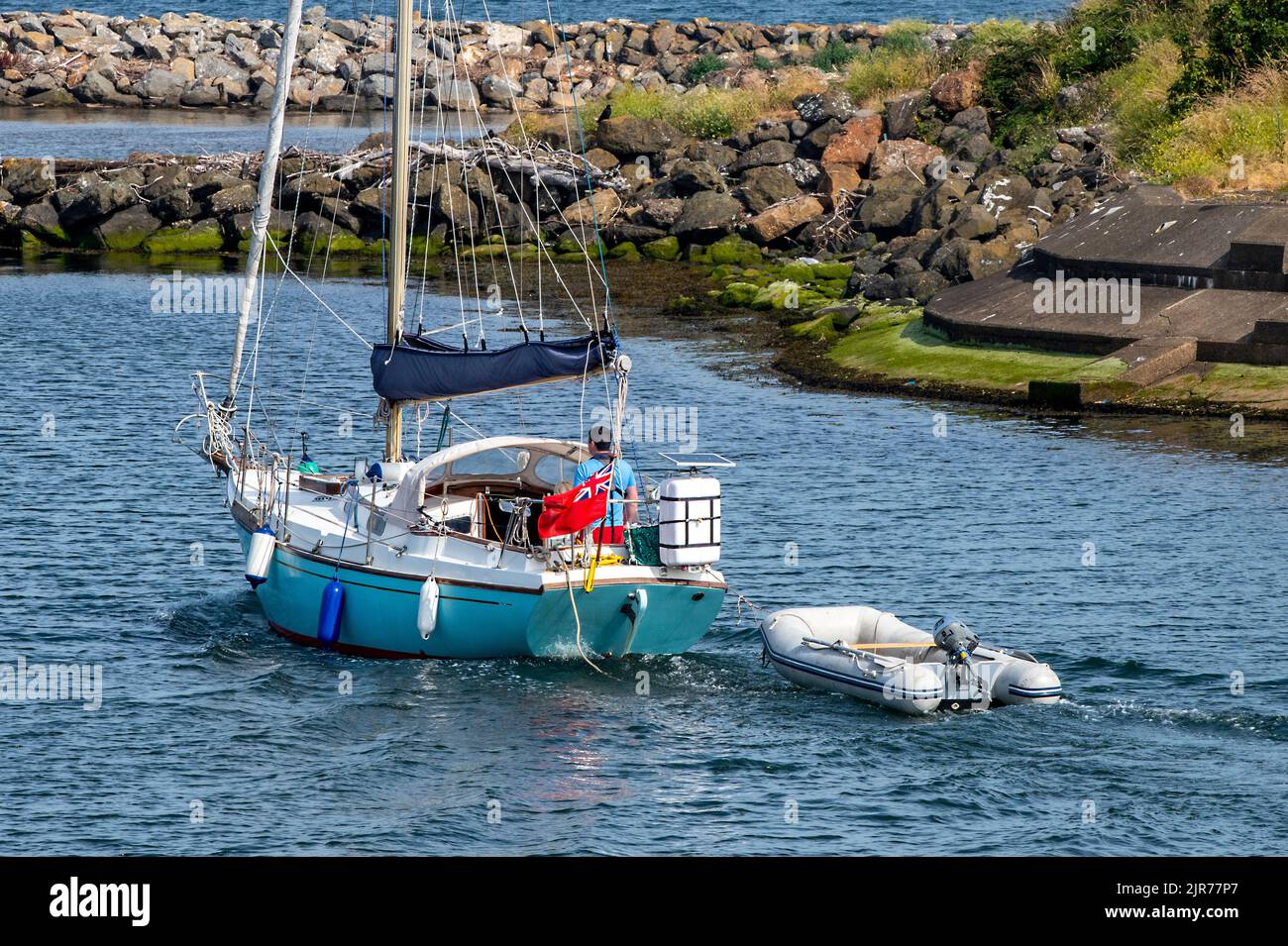 small yacht with a yachtsman at the helm leaving the harbour at girvan ...