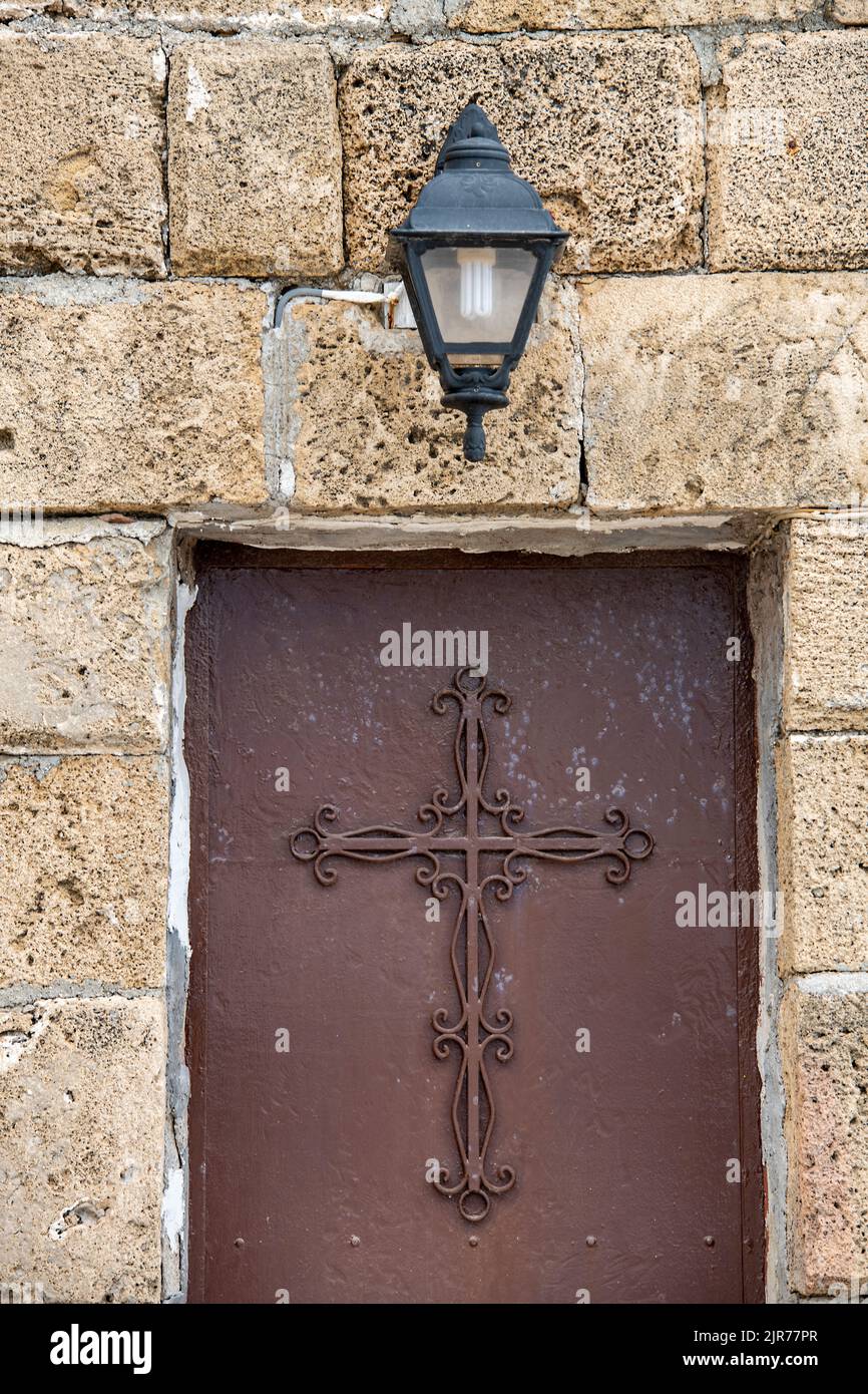 antique lantern above a church door with a cross design on it on a ...