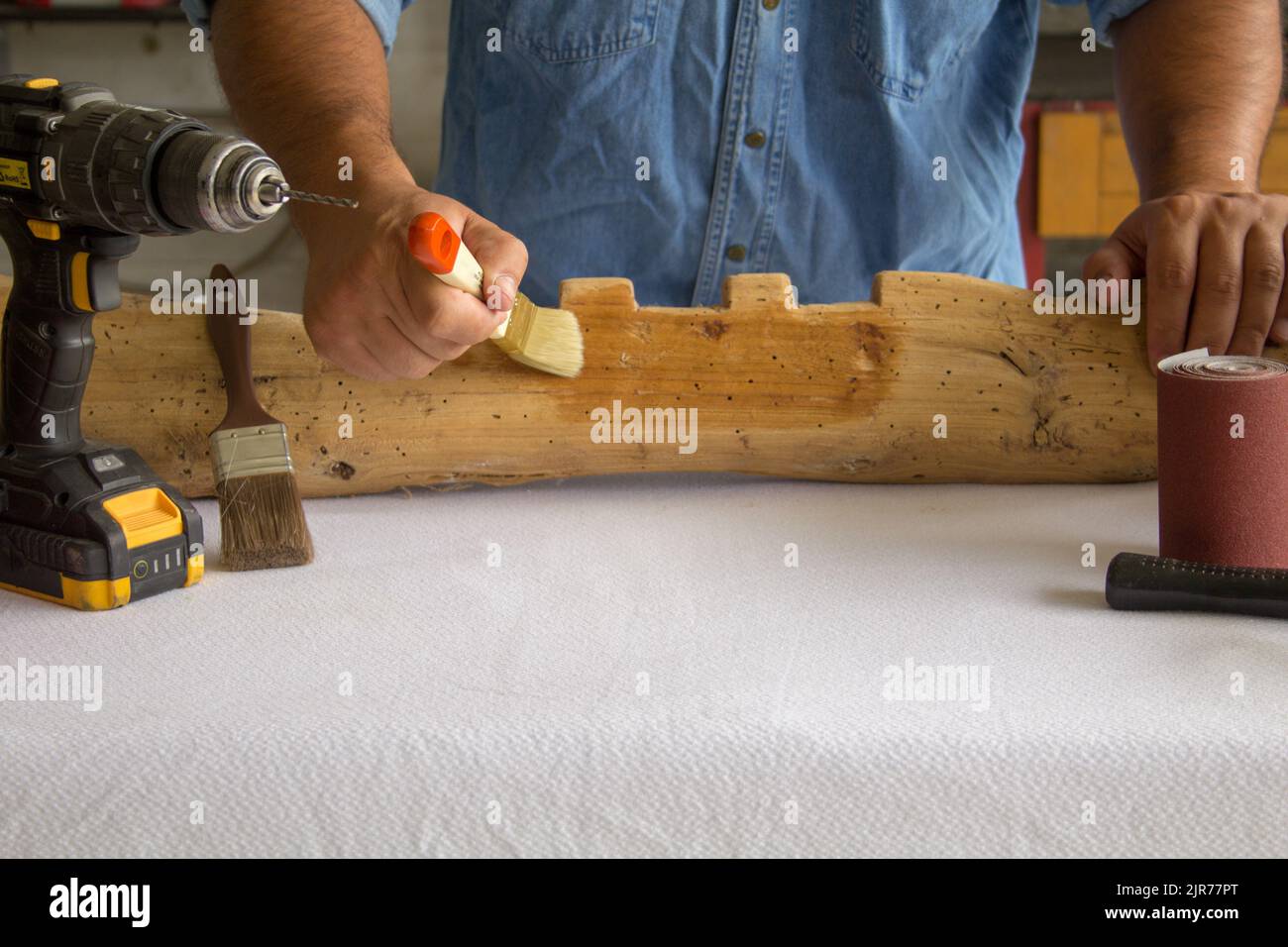 Image of the hands of a craftsman as he passes the protective wood to ...
