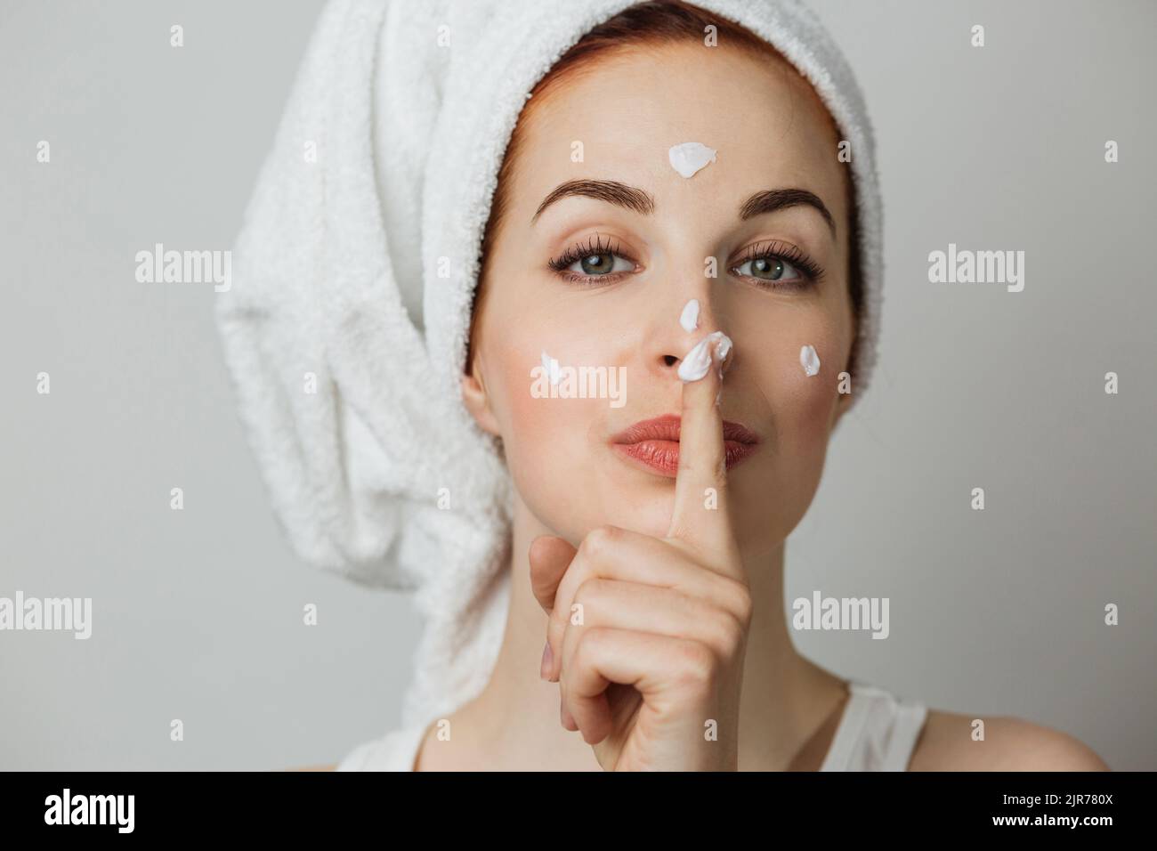 Caucasian young woman using moisturising cream for smoothing skin on ...