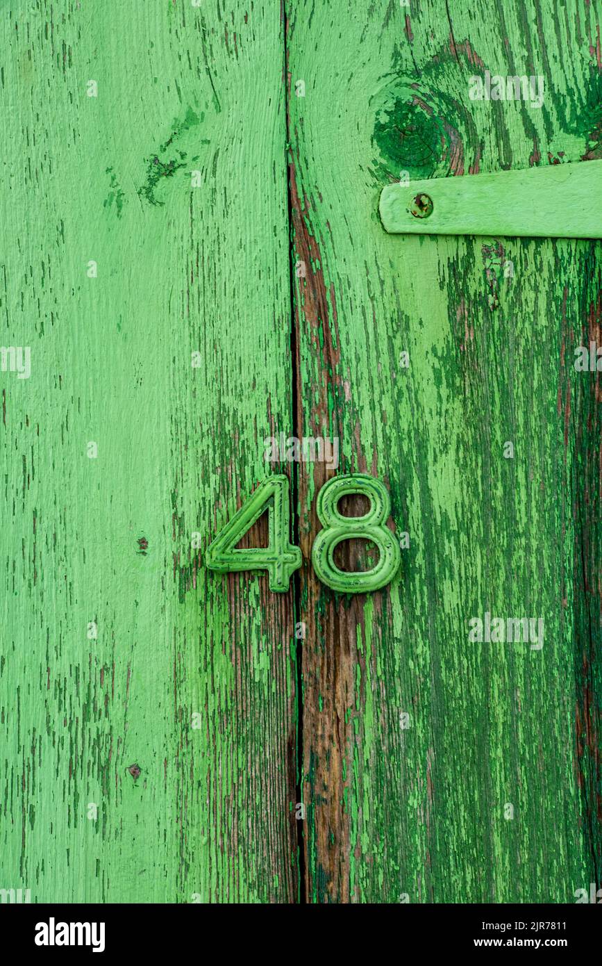 number 48 forty eight on a shabby chic faded green door on a beach hut ...
