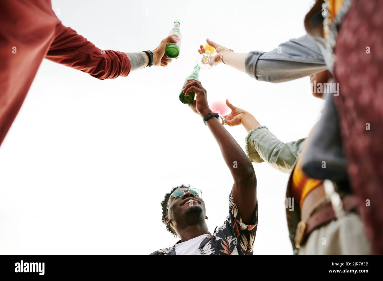 Below angle of young happy intercultural friends cheering up with ...