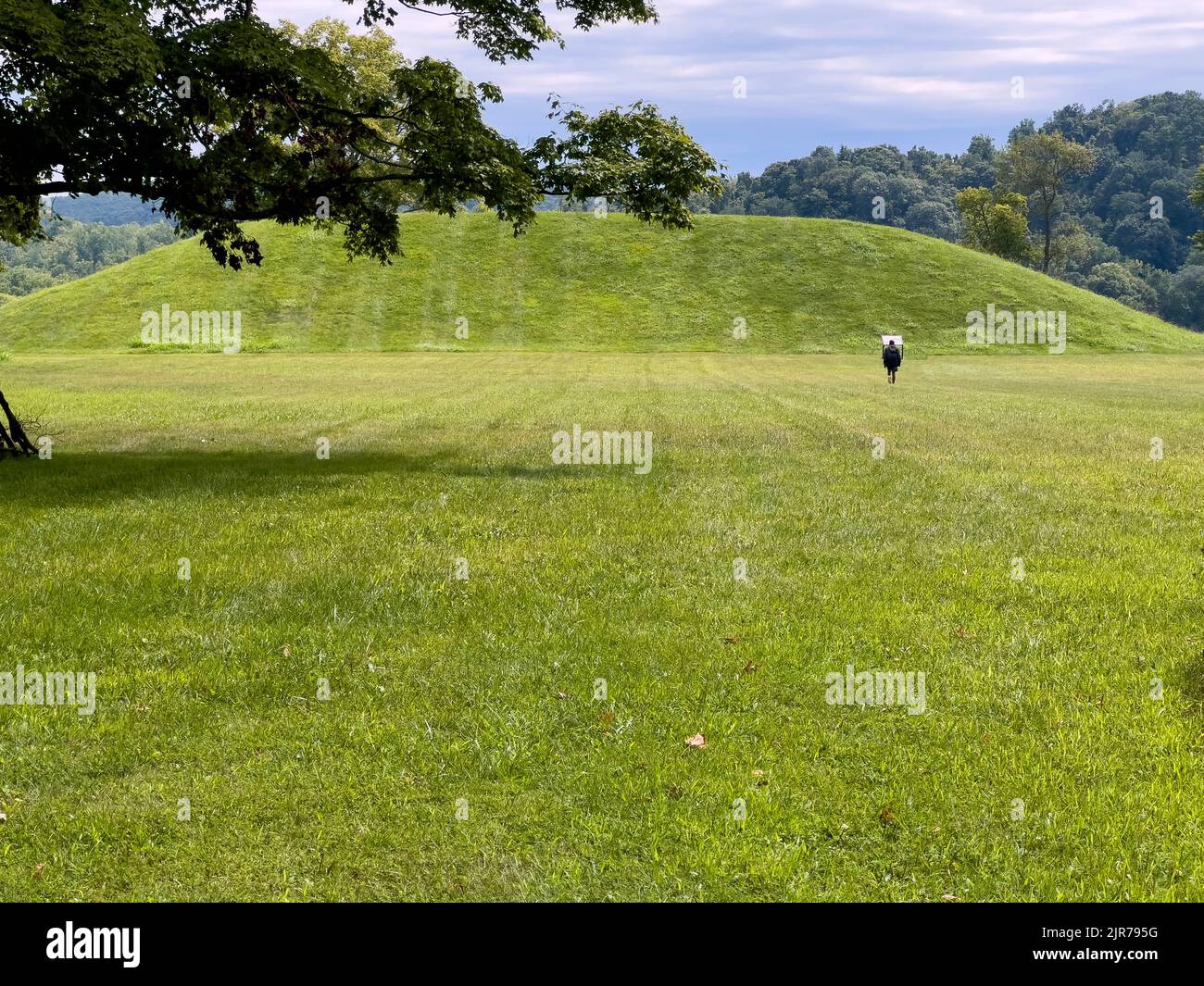 Person walks toward a prehistoric Native American earthwork burial ...