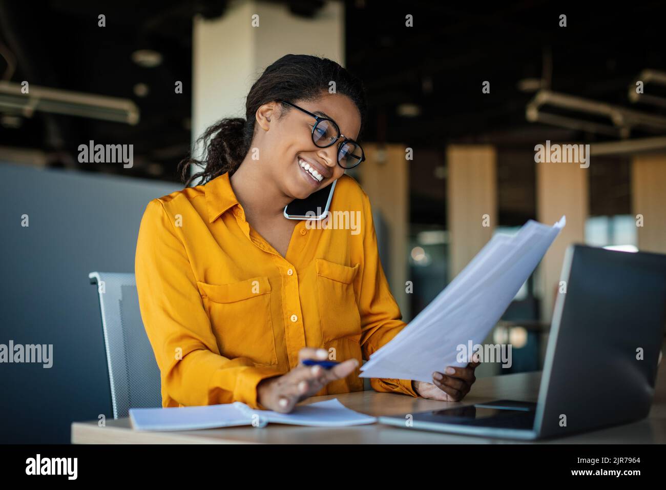 Corporate communication. Happy black female manager working with papers ...