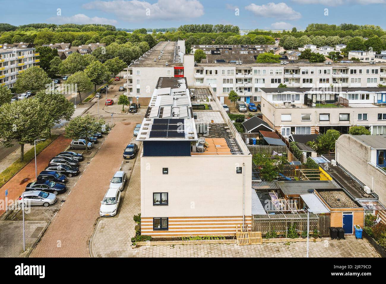 Panorama view of brick houses from an empty sidewalk street with cars ...