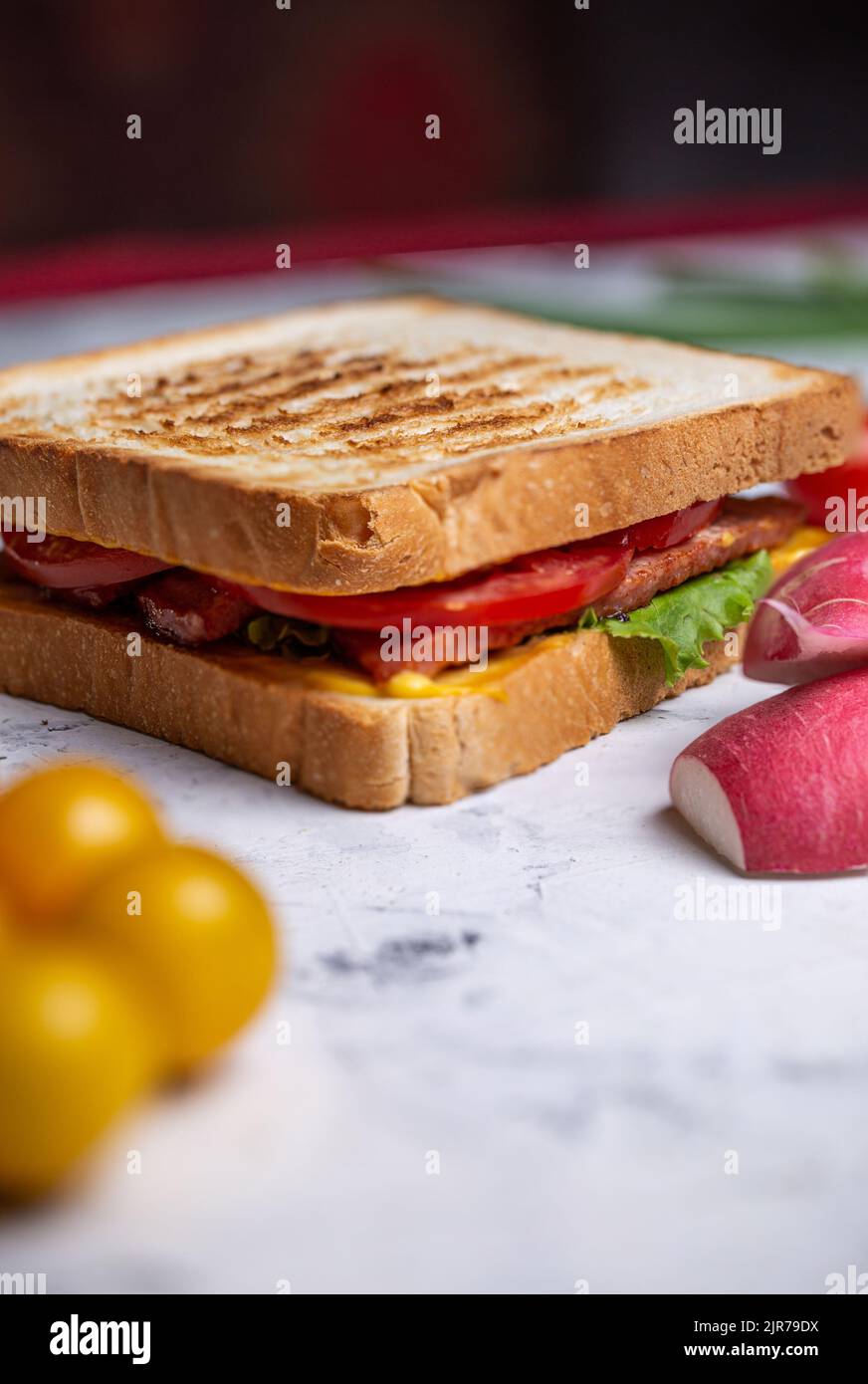 sandwich of two bread toasts close-up with stuffing and vegetables on a ...
