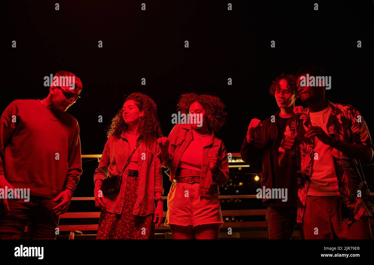 Group of happy young intercultural friends dancing during rooftop party ...