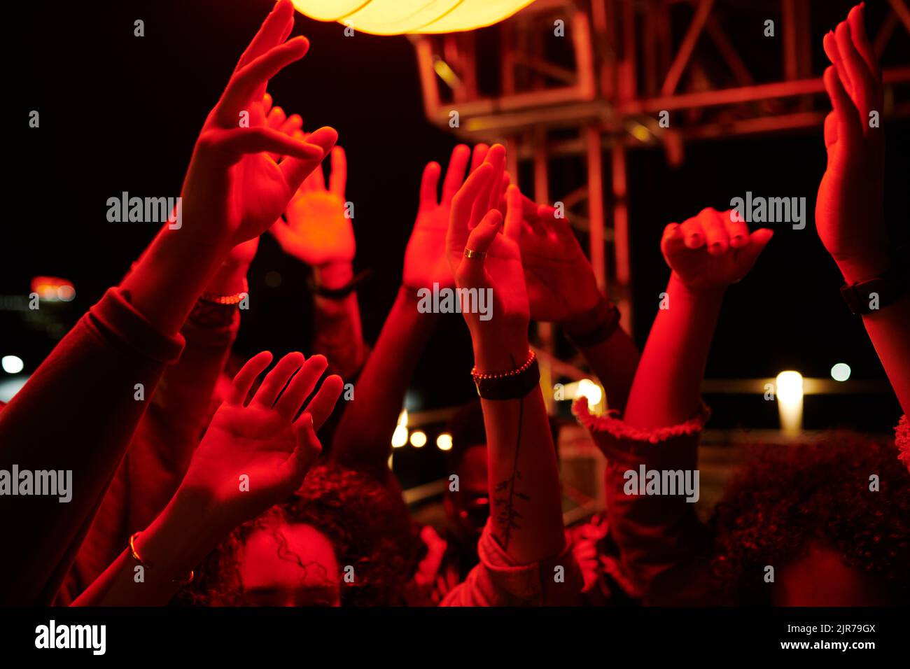 Raised hands of young energetic friends dancing at rooftop party in ...