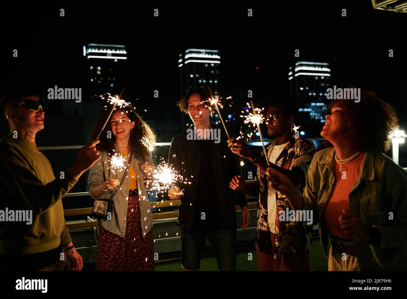 Group of happy youthful multicultural friends with sparkling bengal ...