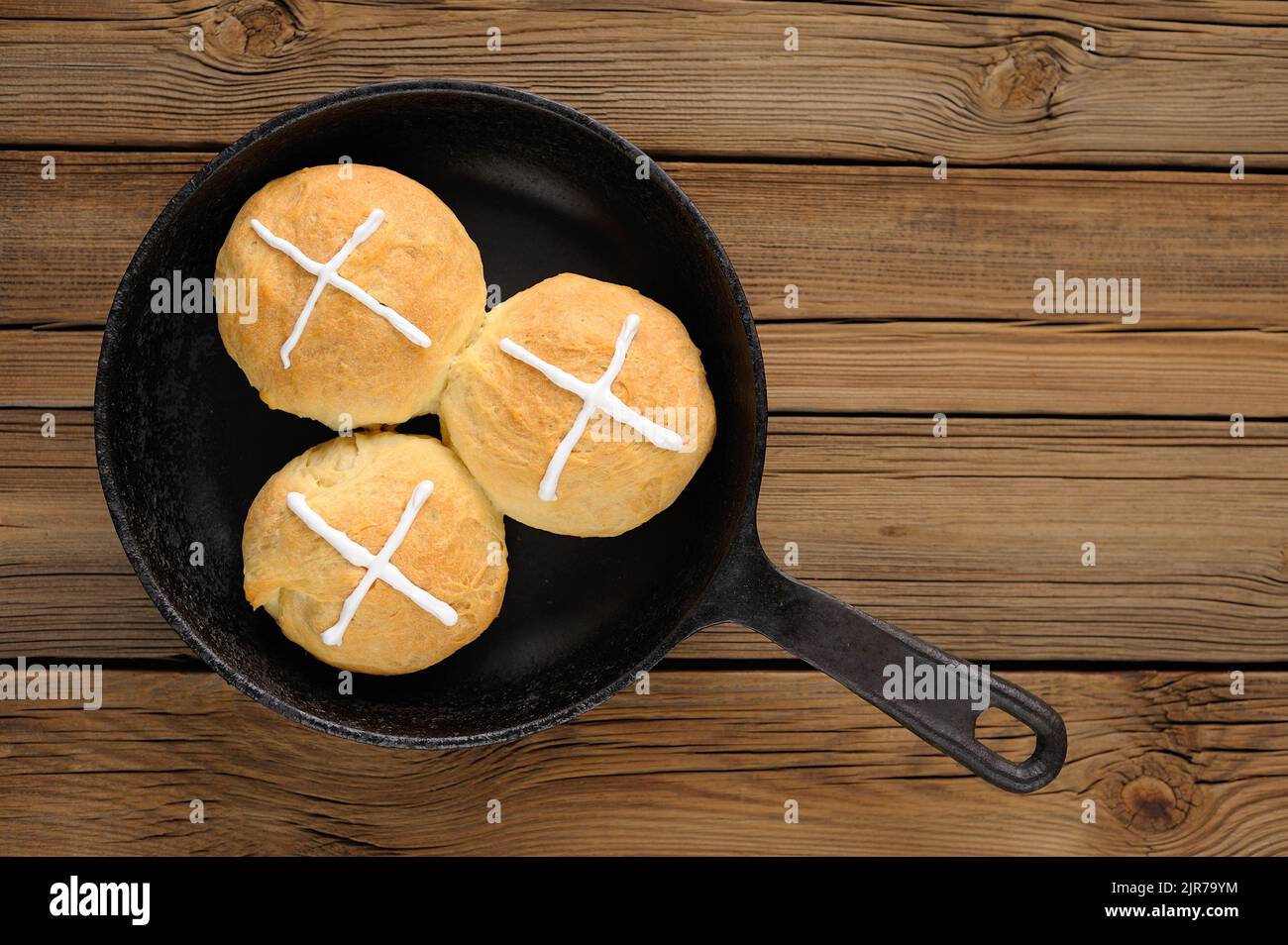 Hot cross buns in cast iron skillet on wooden background with space ...