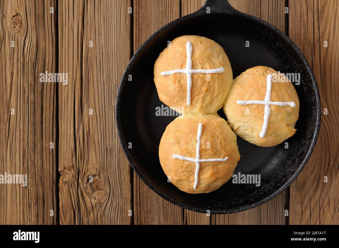 Hot cross buns in cast iron skillet on wooden background with space ...
