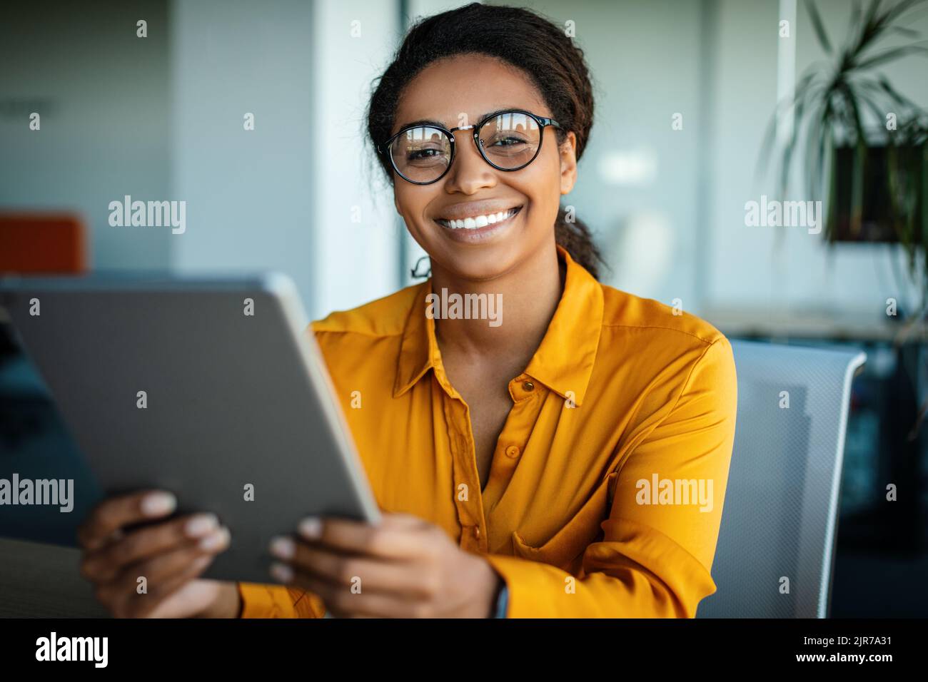 Happy african american business lady using tablet pc at workplace in ...