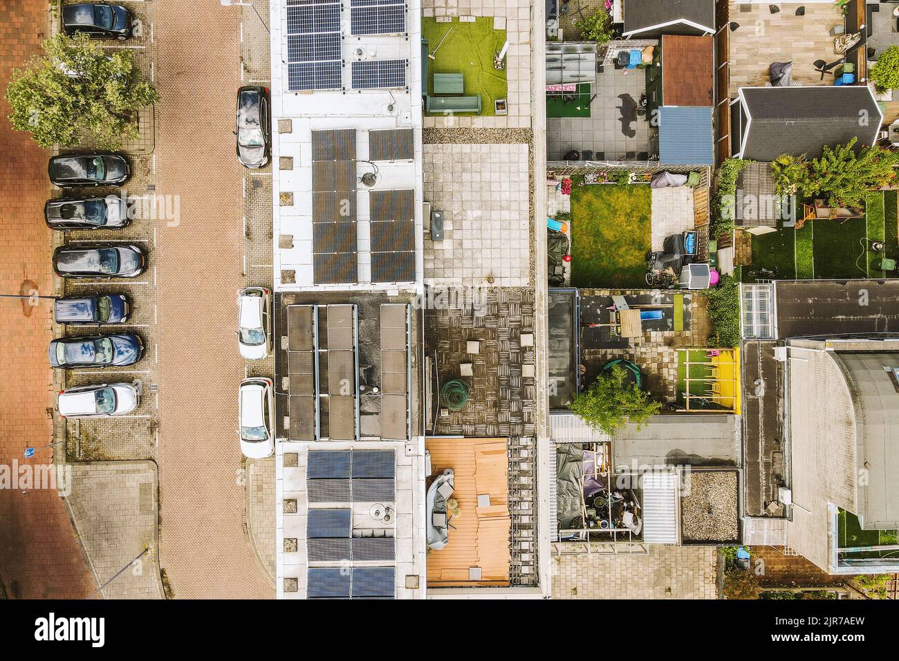 Panorama view of brick houses from an empty sidewalk street with cars ...