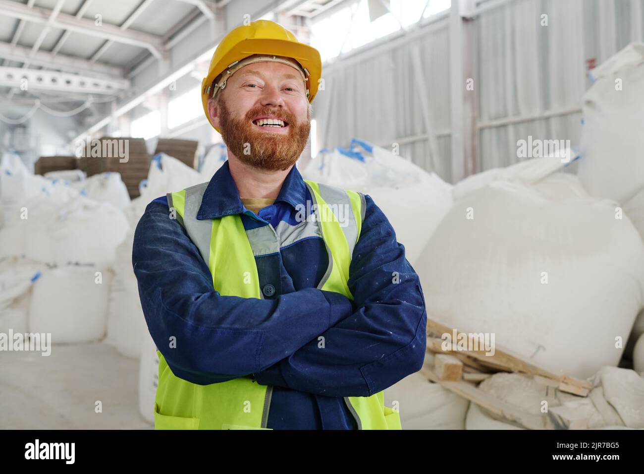 Successful male worker of warehouse of production factory looking at ...