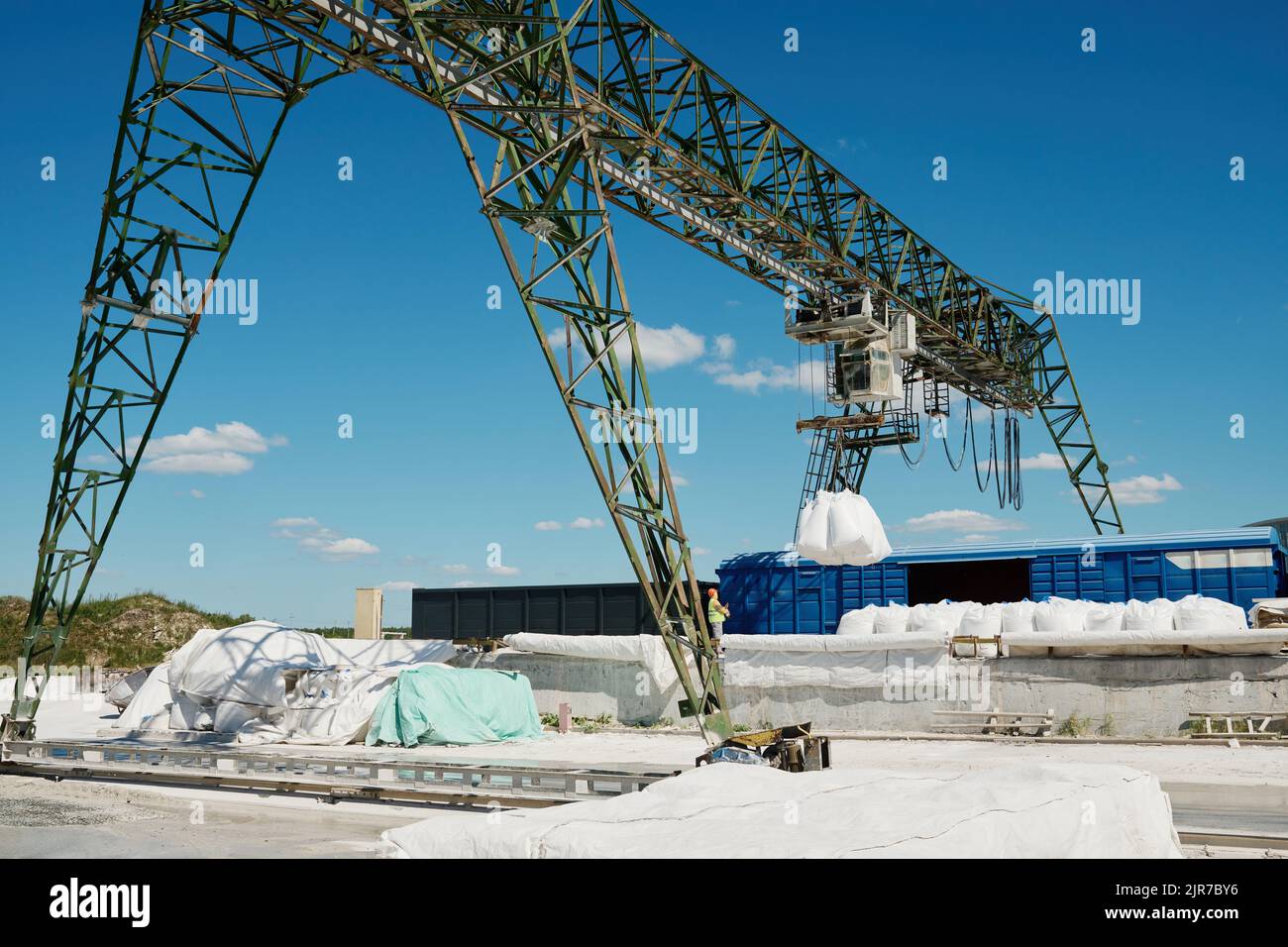 Part of huge structure or industrial machine lifting heavy white sacks ...