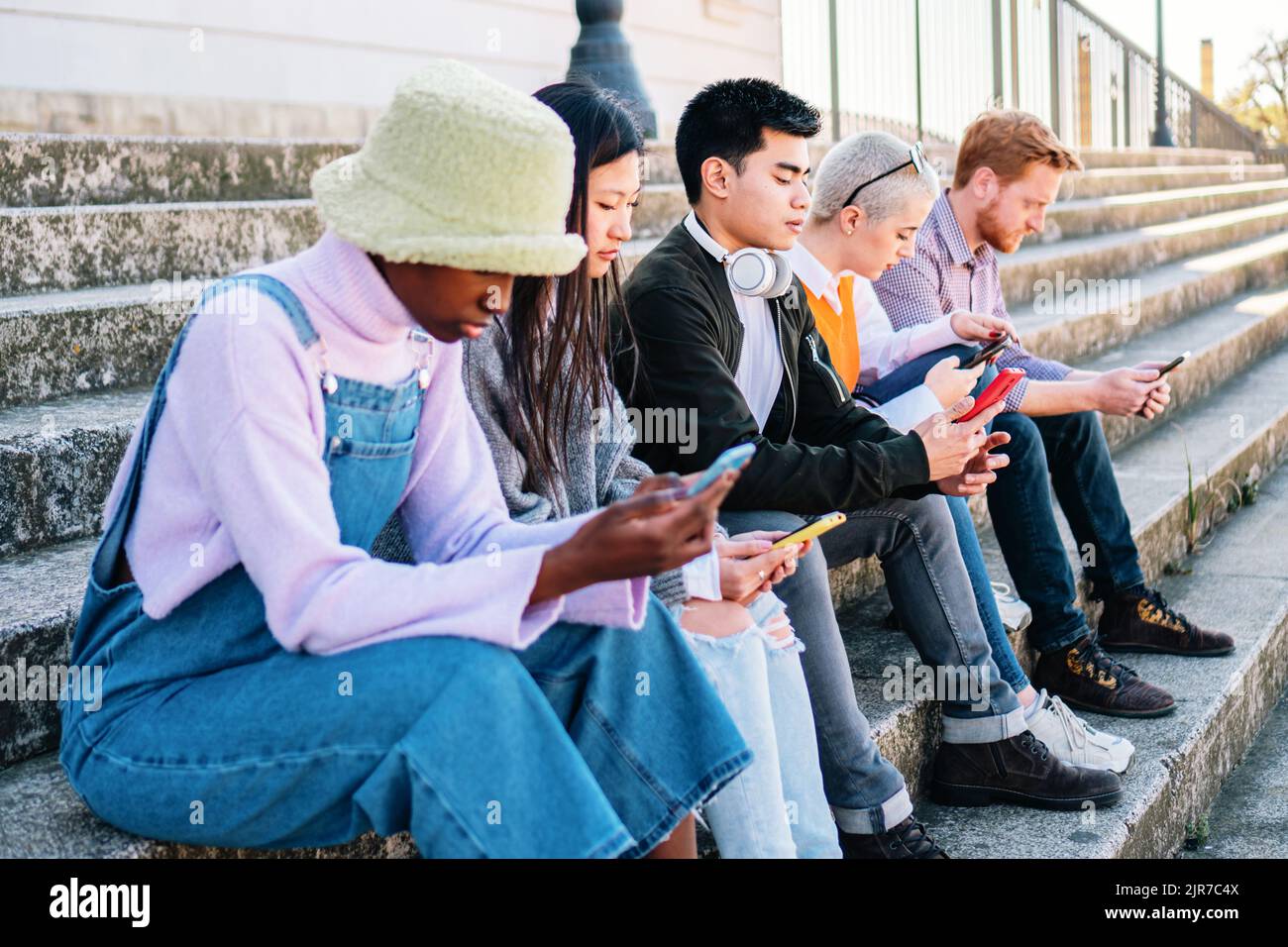 five friends concentrated using their smartphones outdoors Stock Photo ...