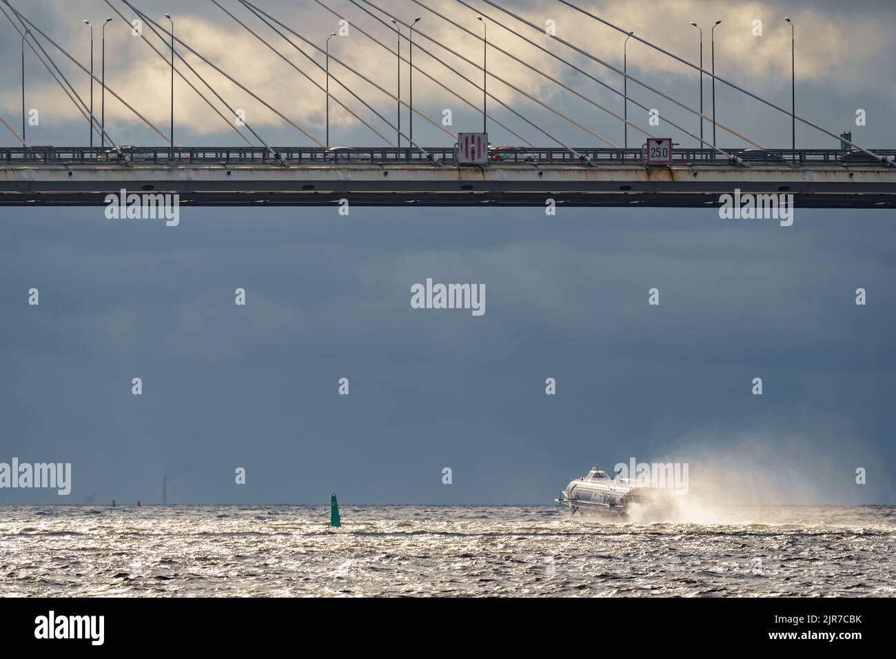a high-speed passenger hydrofoil boat passes under a cable-stayed ...