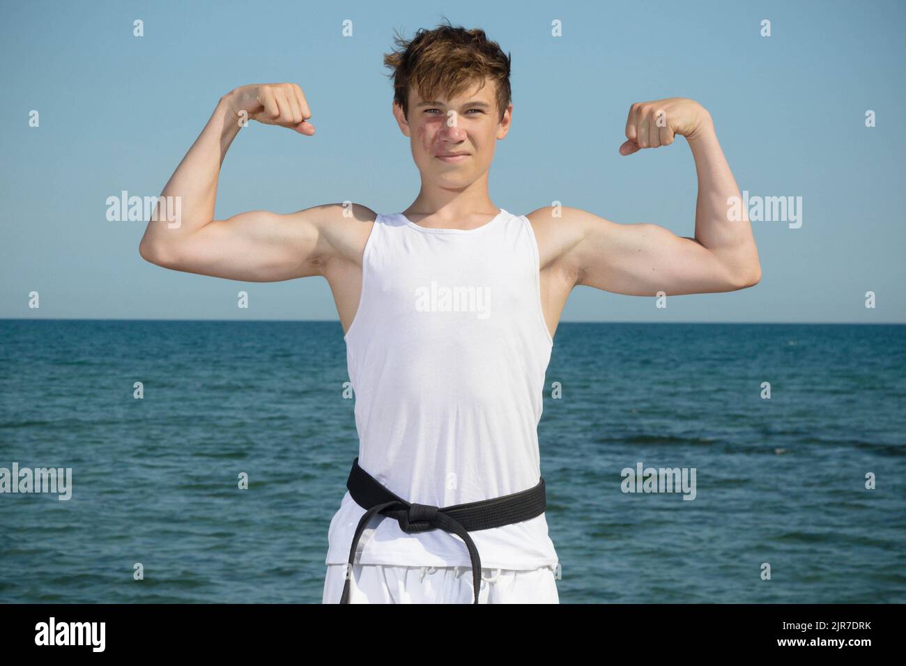 A 17 Year Old Teenage Black Belt Flexing His Muscles on A Beach Stock ...