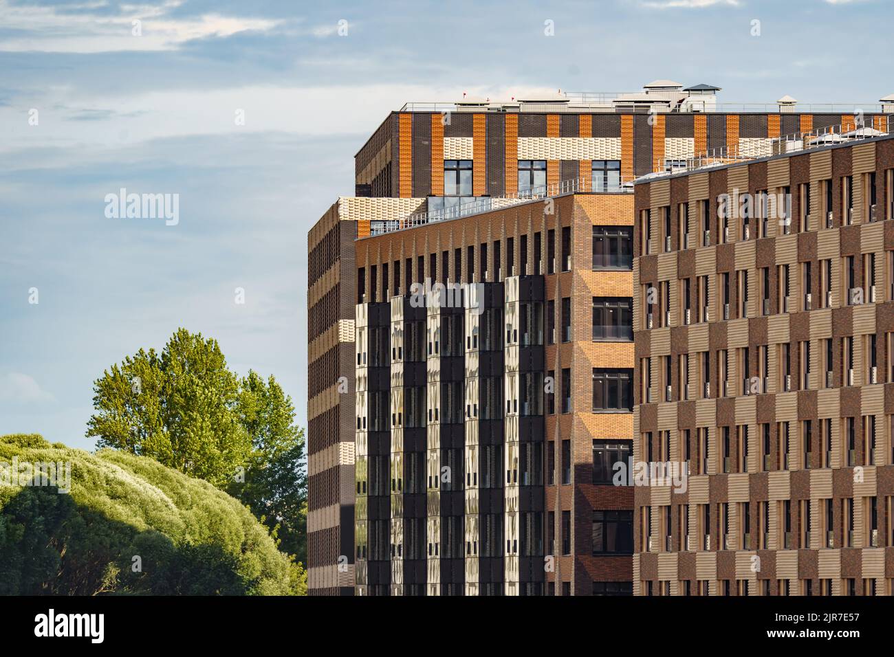 beautiful facade of the new modern building in sunny weather, green ...