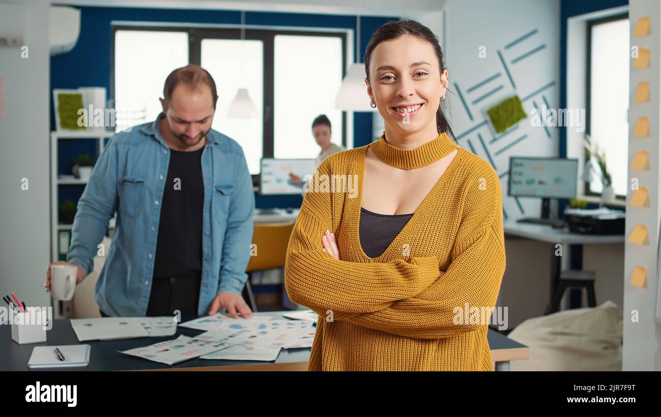 Portrait of confident startup employee entering frame posing with arms ...