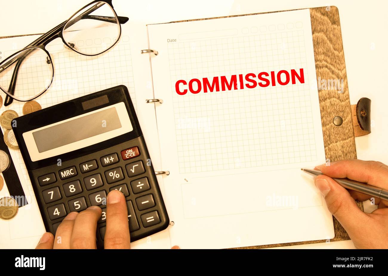 On the office desk there is a burgundy notebook, a calculator, a pen ...