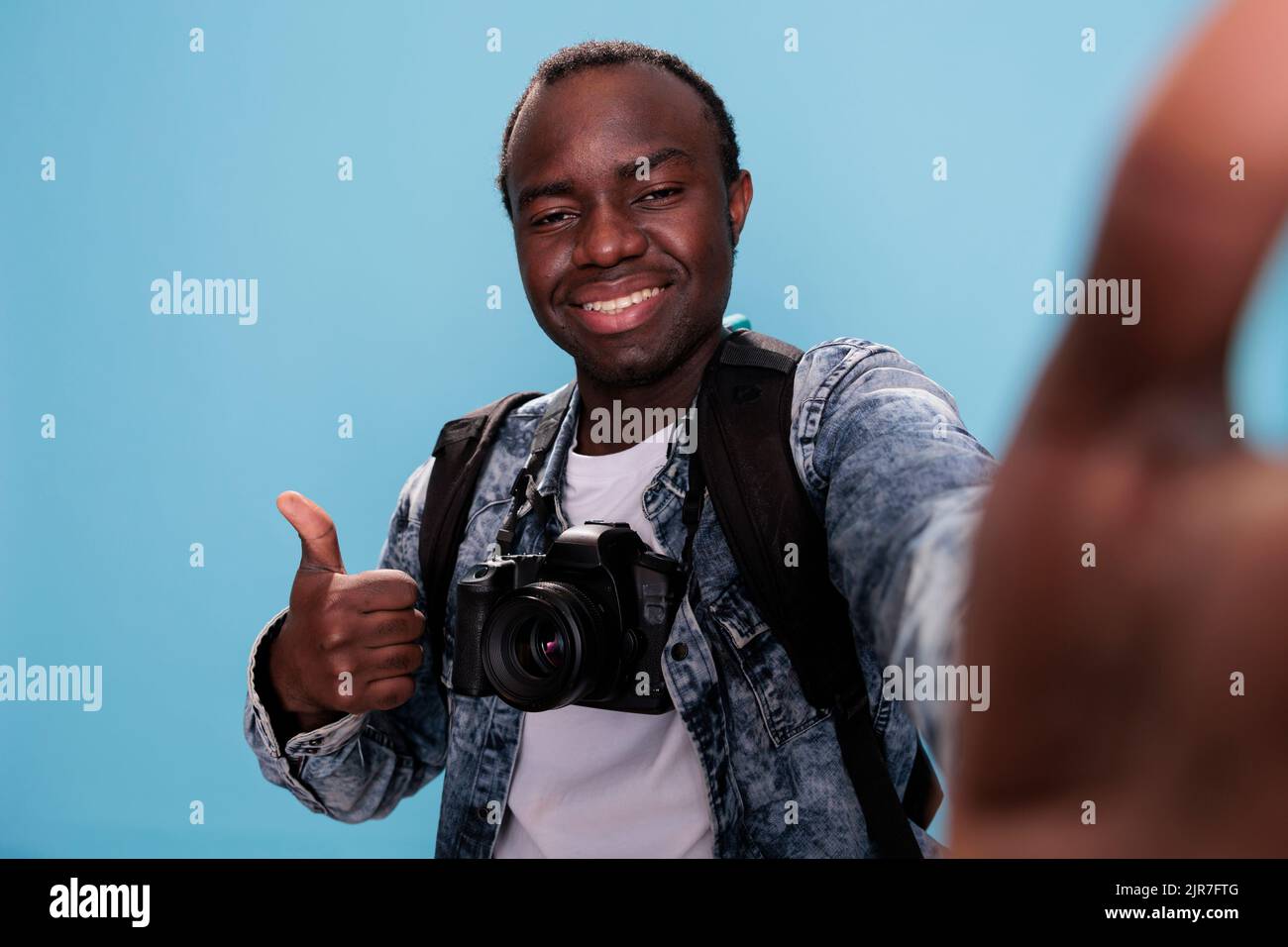 Confident photographer showing okay finger symbol while taking selfie ...