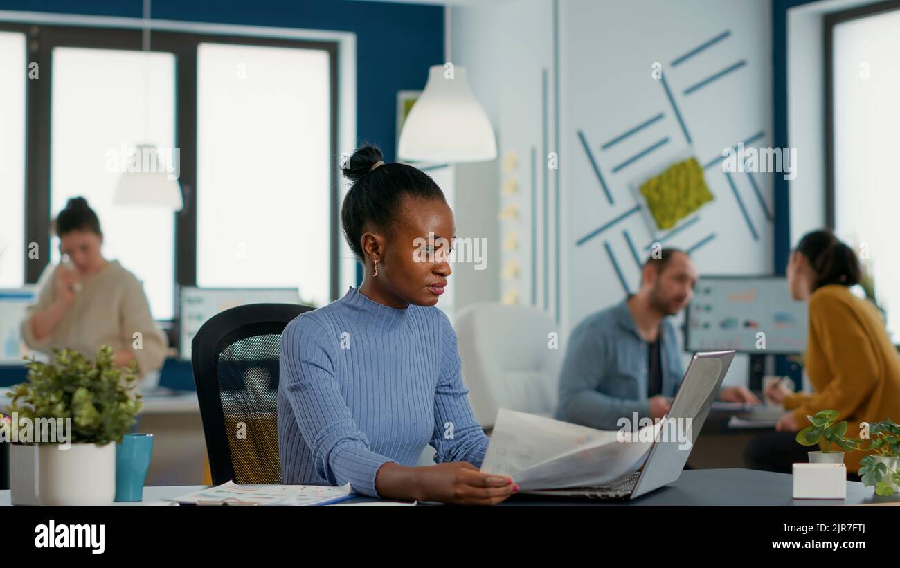 African american startup employee holding business papers with charts ...