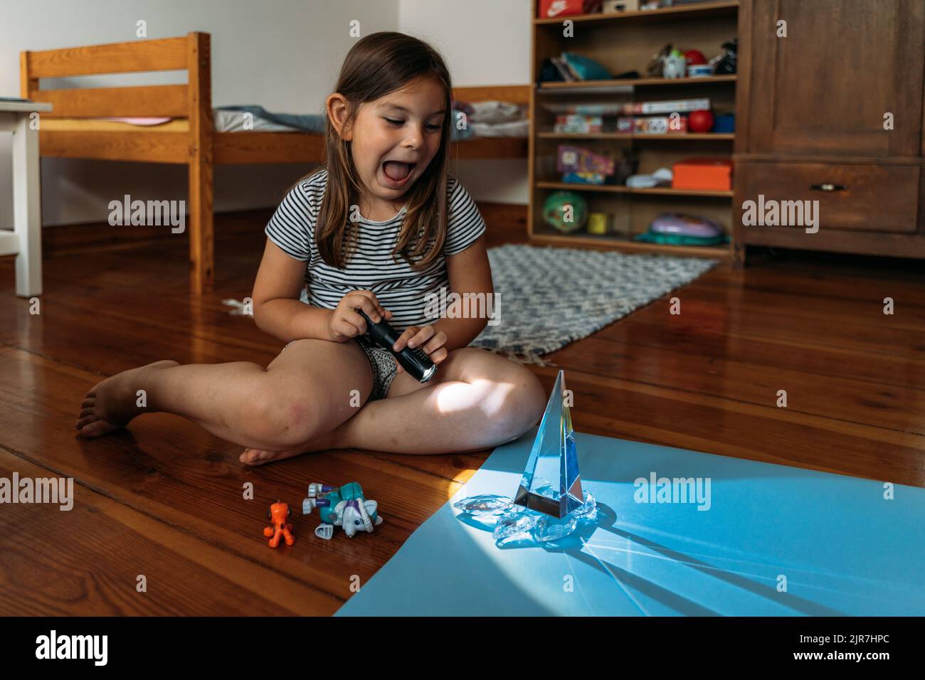 Child girl playing with crystals and torch light, learning about ...