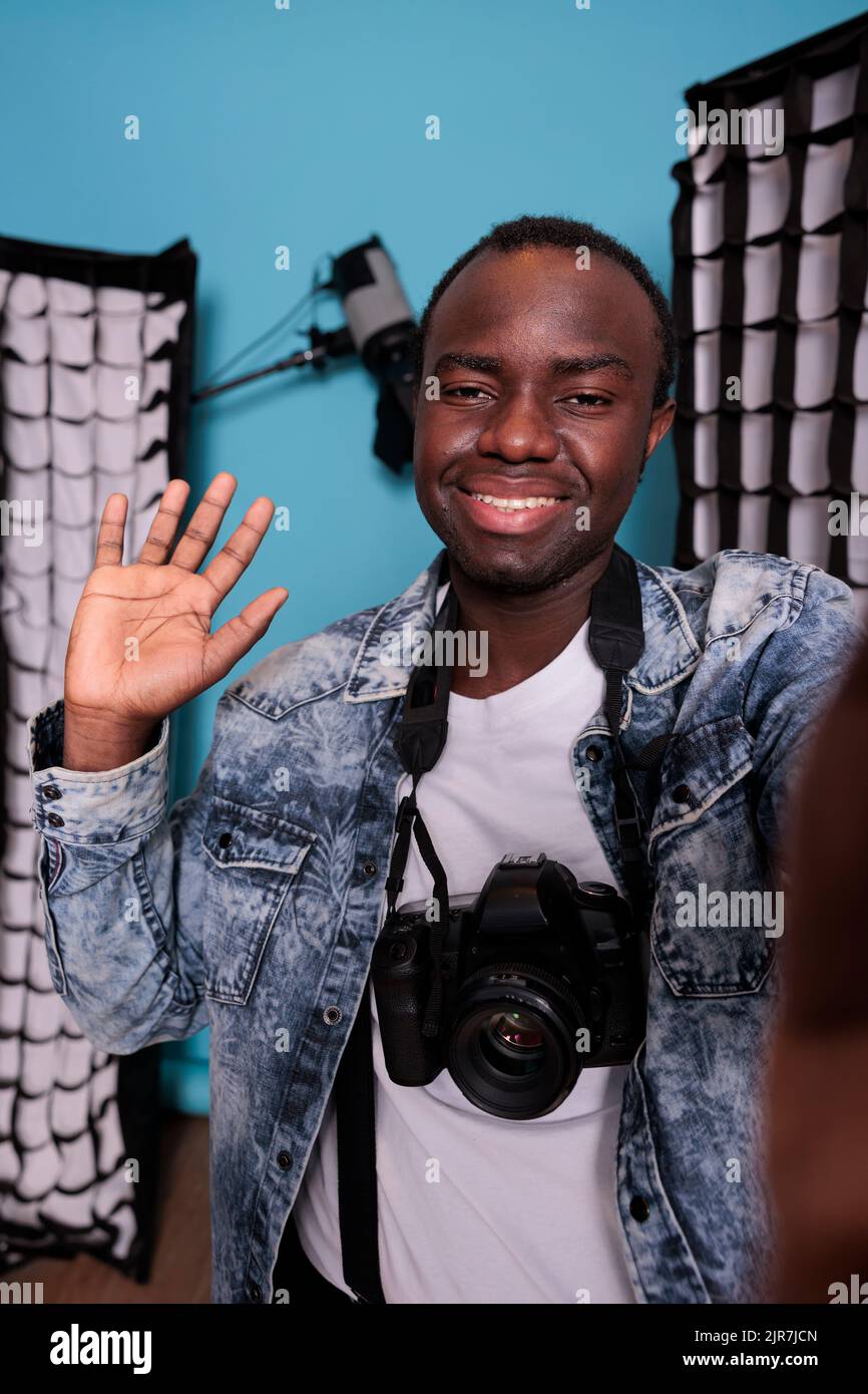 Photography enthusiast with DSLR device taking picture of himself while ...