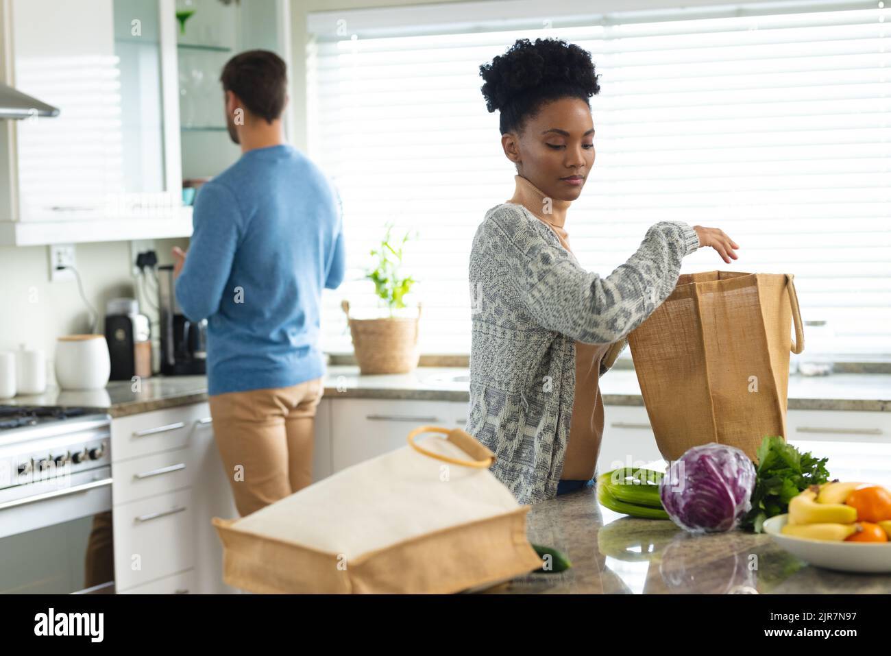 Image of happy diverse couple unpacking groceries in kitchen Stock ...