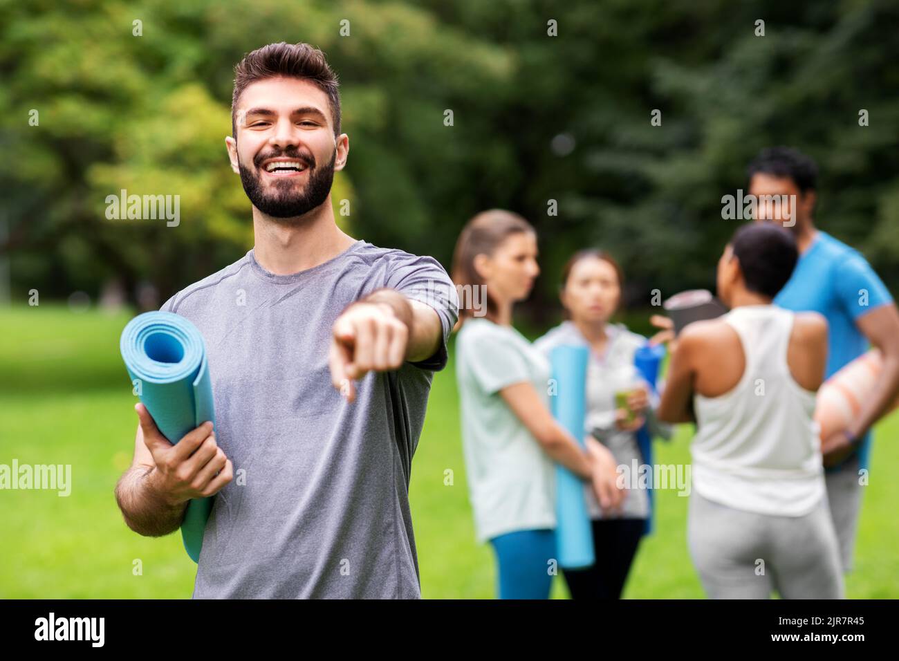 happy man with yoga mat pointing finger to camera Stock Photo - Alamy