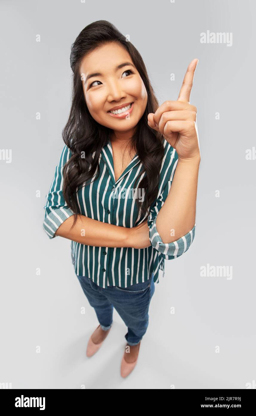 happy smiling asian woman pointing finger up Stock Photo - Alamy