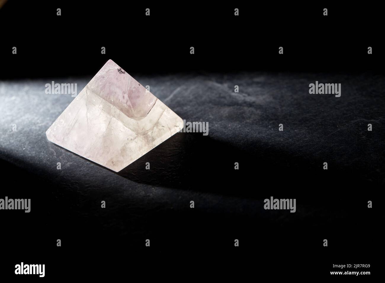 quartz crystal pyramid on slate stone in darkness Stock Photo - Alamy
