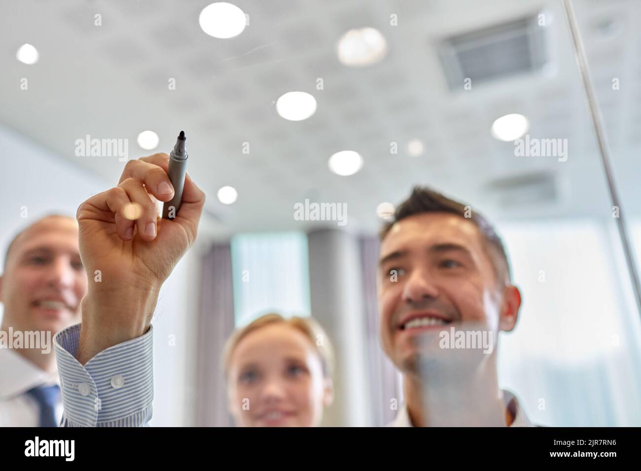 man with marker writing on glass wall at office Stock Photo - Alamy