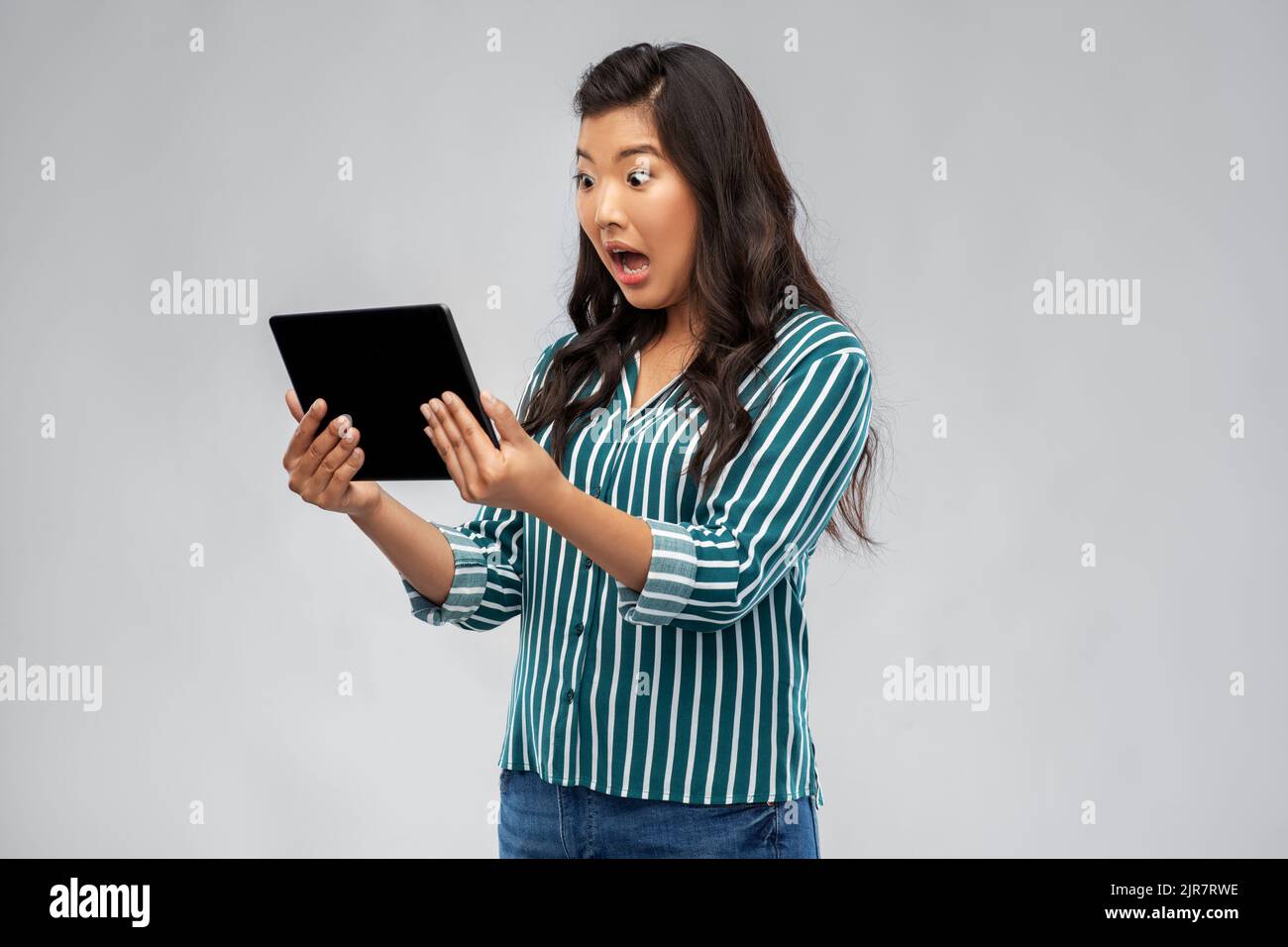 shocked asian woman using tablet computer Stock Photo - Alamy