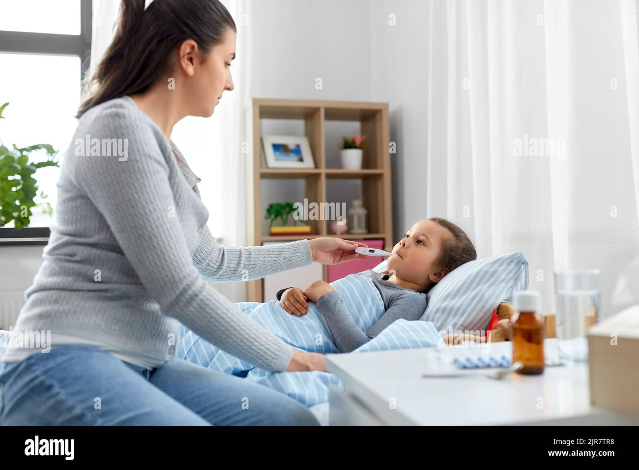 mother and sick daughter measuring temperature Stock Photo - Alamy