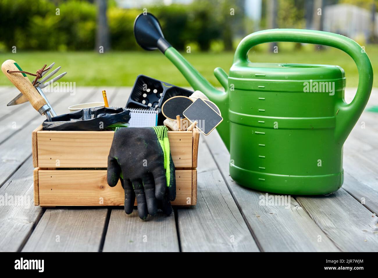 box with garden tools and watering can in summer Stock Photo - Alamy