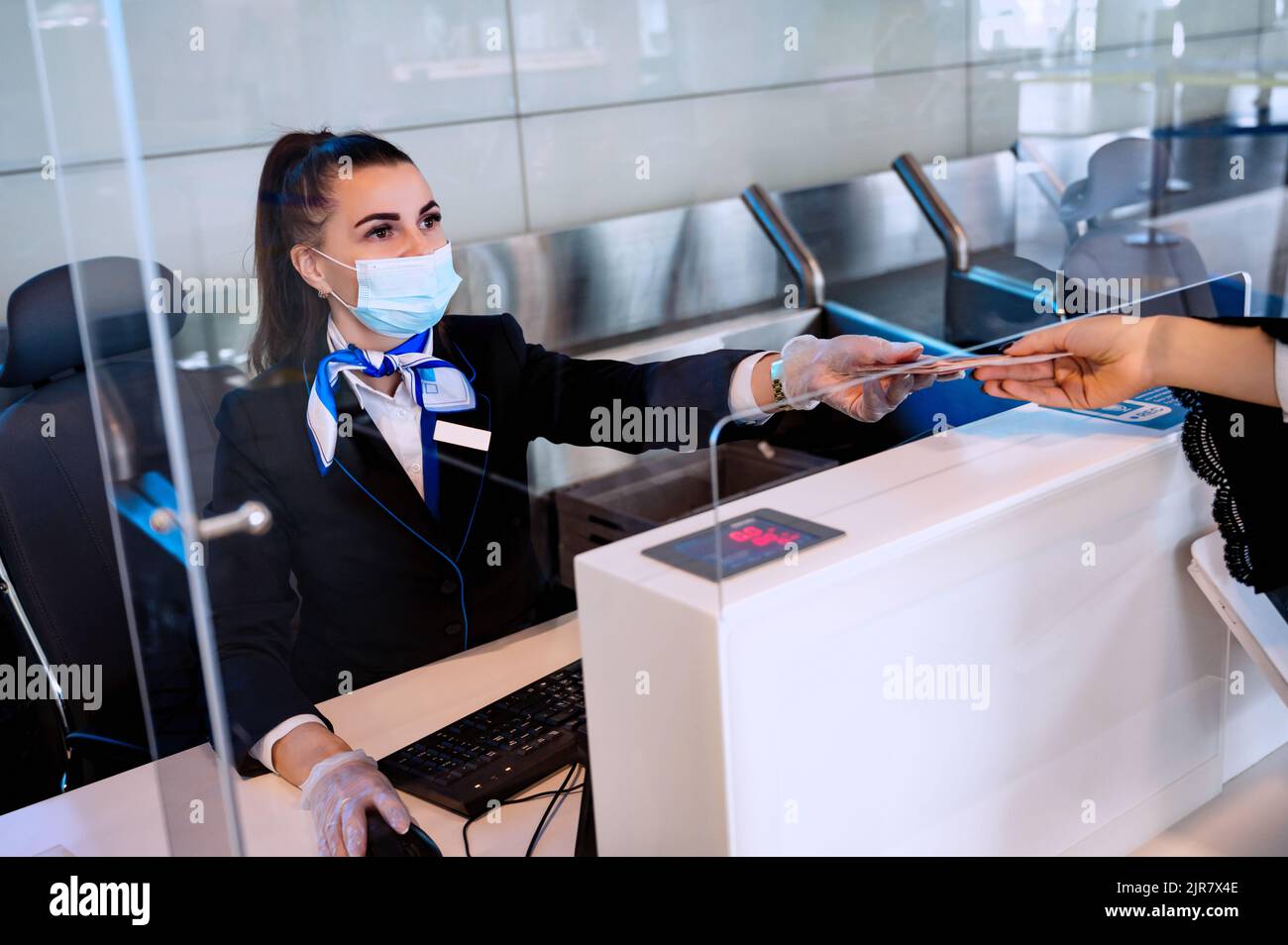 Beautiful girl on checking-in her tickets and receiving boarding pass ...