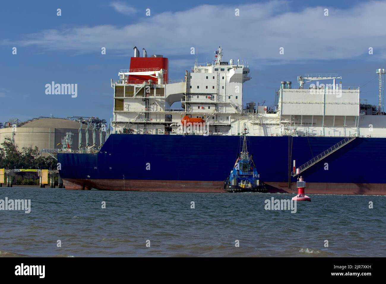 Large LNG Tanker cargo ship docked at an industrial port with clear ...