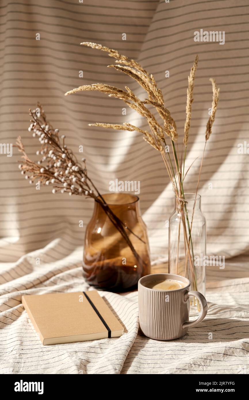 cup of coffee, diary and dried flowers in vases Stock Photo - Alamy