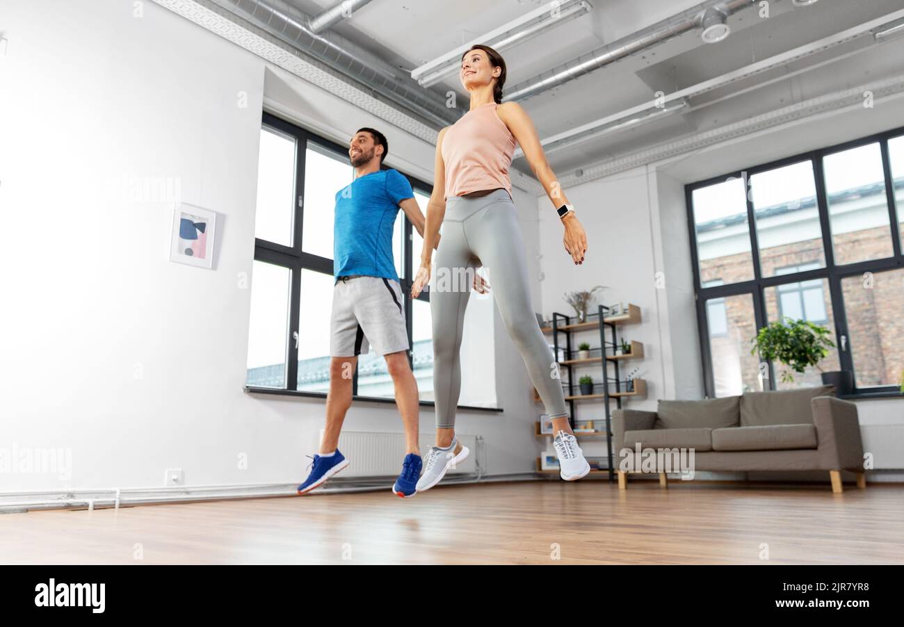 happy couple exercising and jumping at home Stock Photo - Alamy