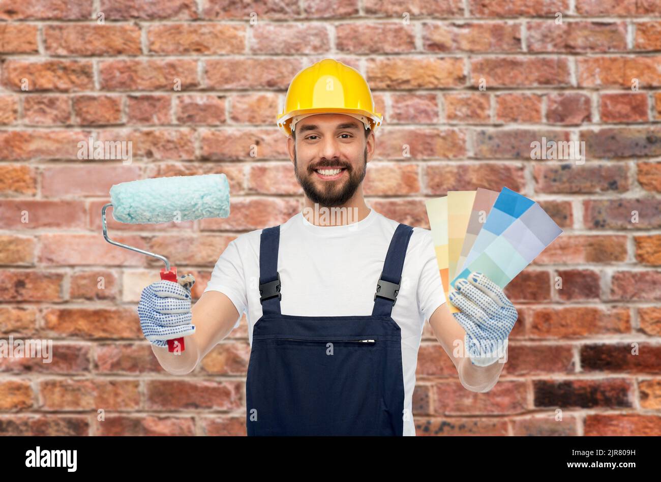male builder with paint roller and color palettes Stock Photo - Alamy