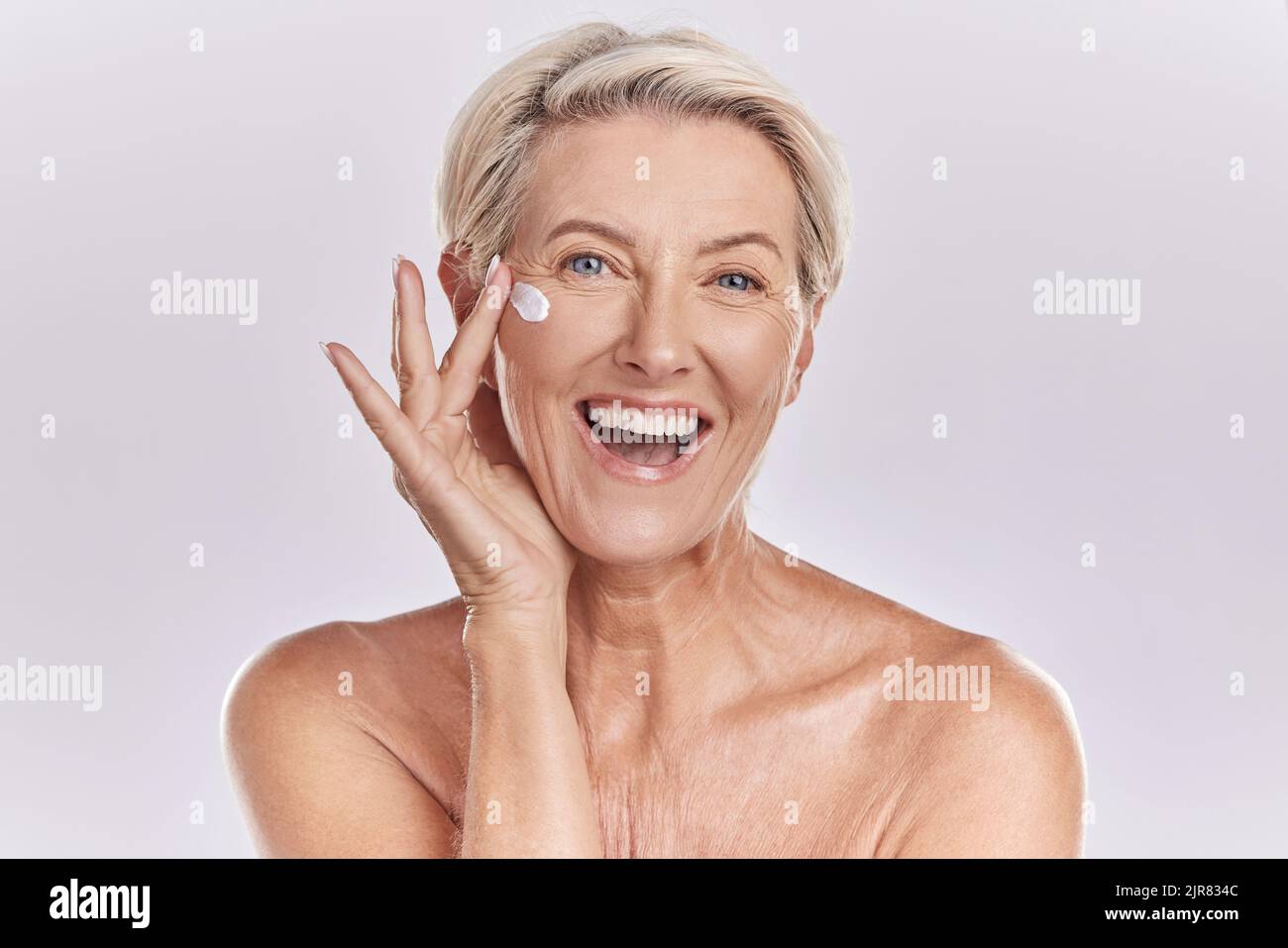 Skin, skincare or collagen lotion with old woman posing with a smile ...