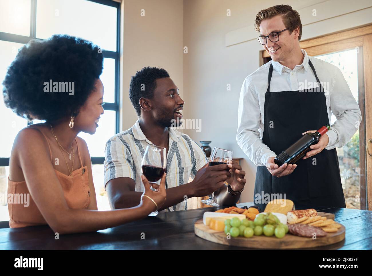 Hospitality industry, restaurant service and waiter showing wine to ...