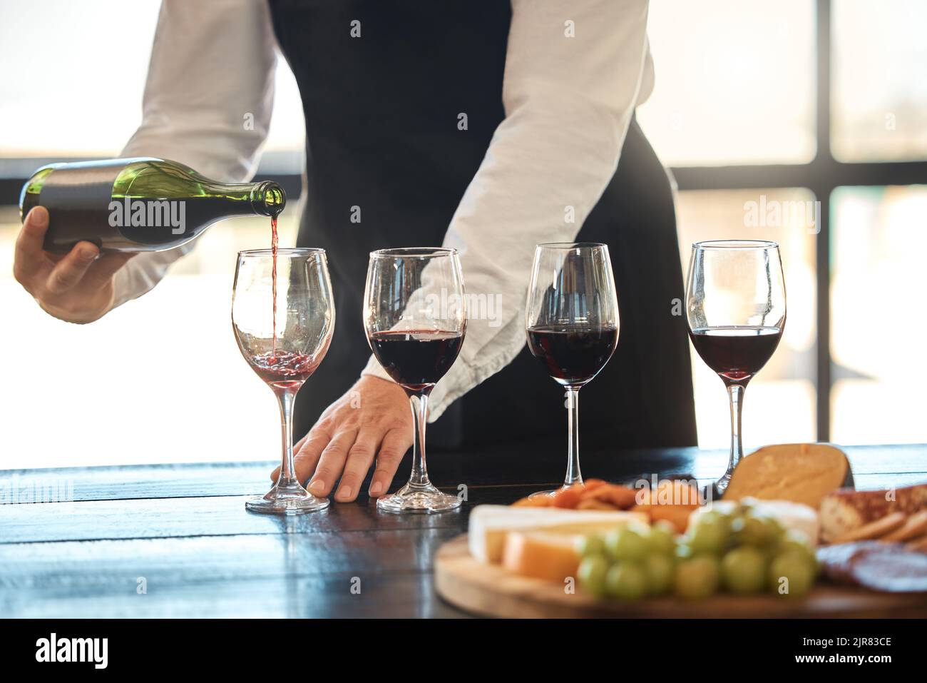 Luxury, fine dining and hospitality with a waiter pouring red wine at a ...