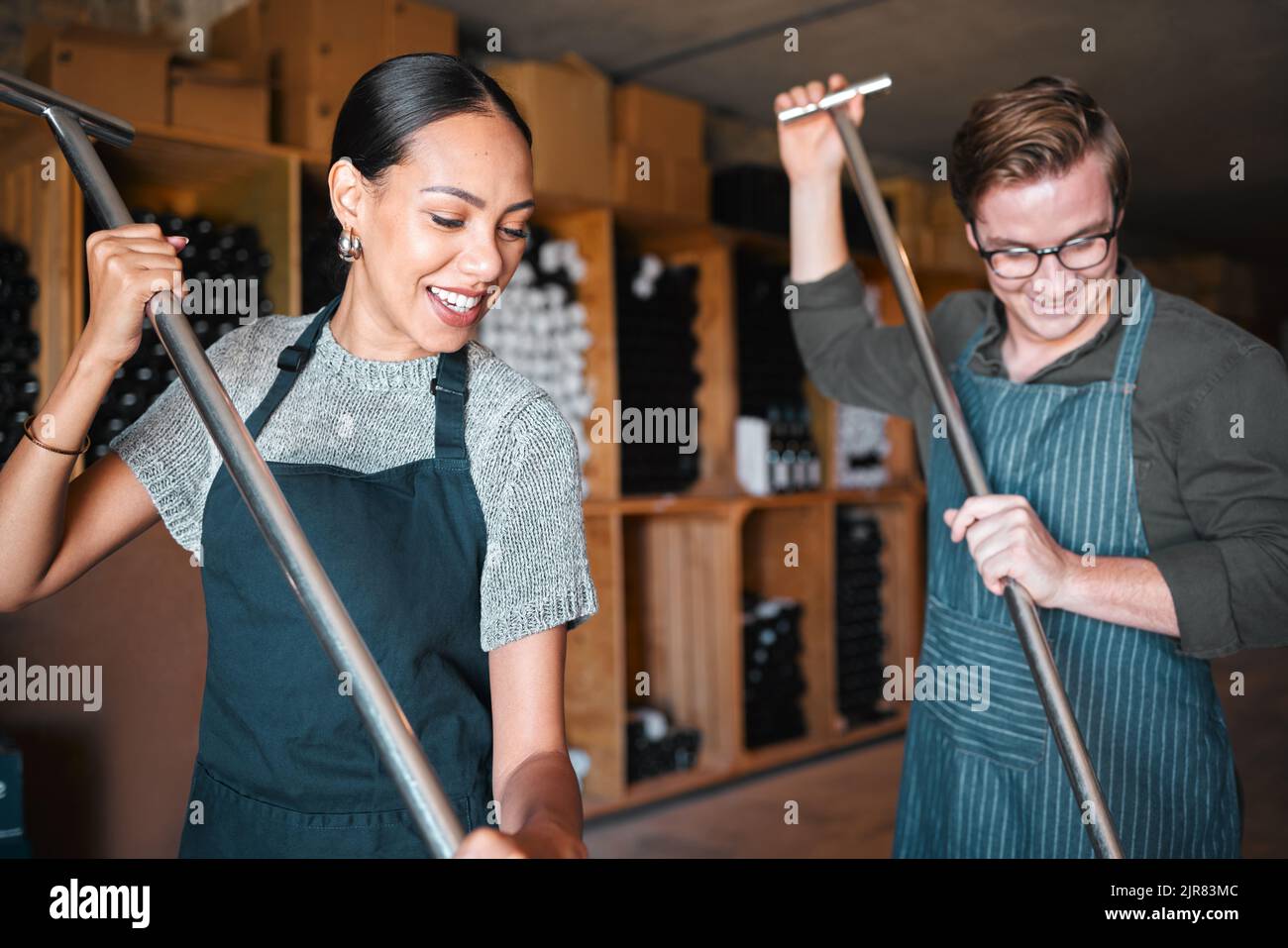 Winemaker workers in wine production using press tool for mixing or ...