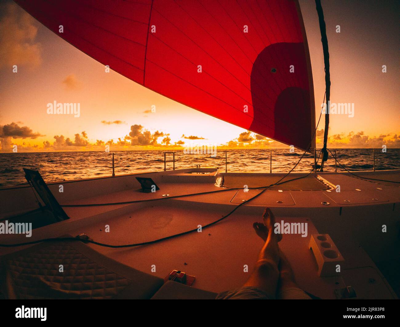 The legs of a man chilling in a Sailing Catamaran Yacht in the Atlantic ...