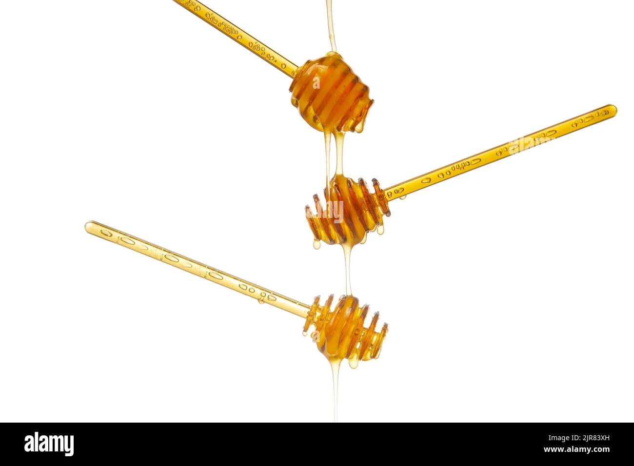 Fresh floral honey drips from a spoon into a spoon on a white ...